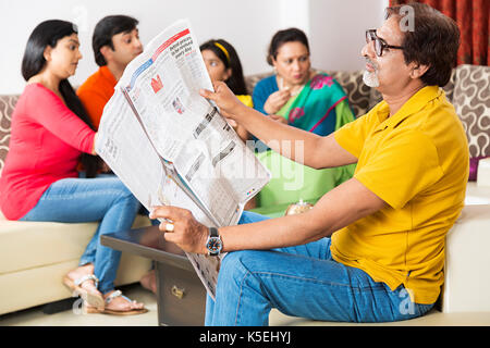 Joint family reading a newspaper Stock Photo - Alamy