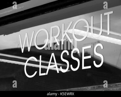 Workout classes sign in gymnasium window Stock Photo - Alamy