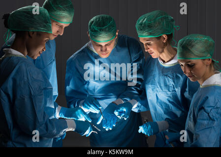 Doctors at work. Diverse group of surgeons working together wearing ...