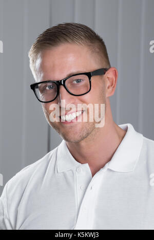 Portrait of a happy handsome man wearing t-shirt standing isolated over ...