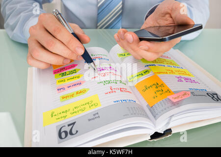 Businessman Writing Schedule In Diary Stock Photo - Alamy