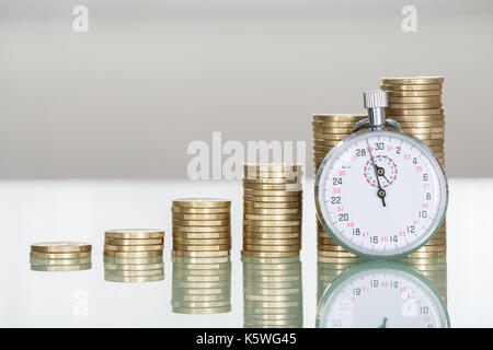 Close up coin stacked growing on financial graph chart in laptop screen ...