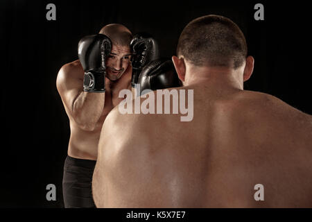 Two muscular men fighting, bodybuilders punching each other, training ...