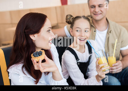 Happy family eating desserts together at cozy cafe and having fun Stock ...