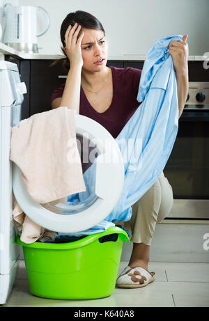 Adult woman with musty towels after laundry at home Stock Photo - Alamy