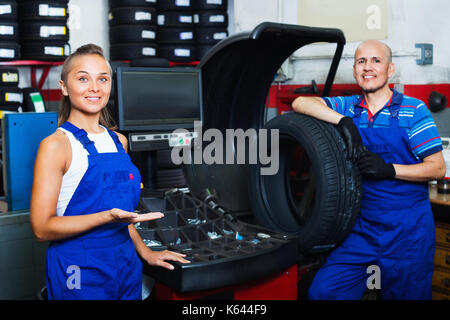 two mechanics operating wheel equilibrium control machinery Stock Photo ...