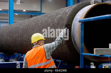 A steel pipe is coated in concrete in the Wasco coating plant on the ...
