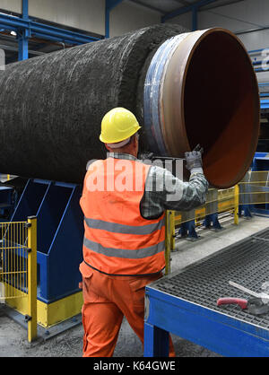 A steel pipe is coated in concrete in the Wasco coating plant on the ...