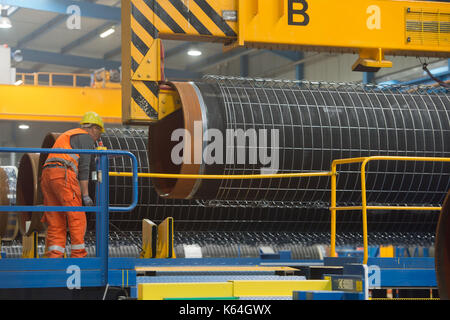 A steel pipe is coated in concrete in the Wasco coating plant on the ...