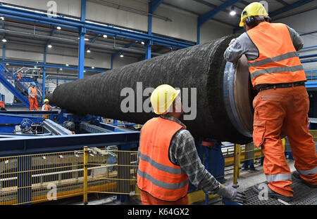 A steel pipe is being coated in concrete in the Wasco coating plant on ...