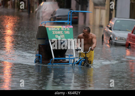 Makati City, Philippines. 12th Sep, 2017. Residents wade through flood ...