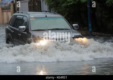 Makati City, Philippines. 12th Sep, 2017. Residents wade through flood ...