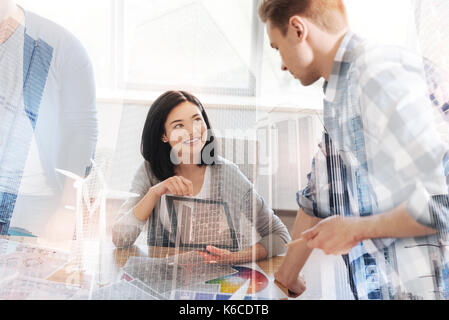 Young team of progressive specialists are busy discussing work tasks ...