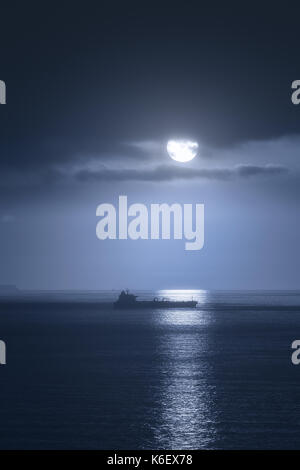 cargo ship at night with moonlight Stock Photo - Alamy