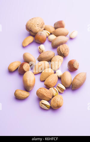 Tasty pistachio nuts on purple background Stock Photo - Alamy