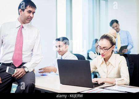 Indian manager supervising his employees team in observation room ...
