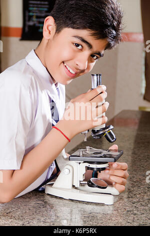 Young boy scientist with microscope examining a sample Stock Photo - Alamy
