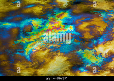 Rainbow coloured oil spill on wet Tarmac road surface Stock Photo - Alamy