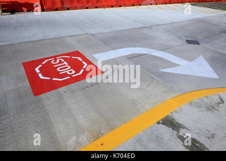 Stop sign and arrow painted on road in shopping centre car park Stock ...