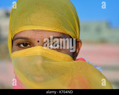 Pretty young Indian woman covering her face at home in Narlai village ...