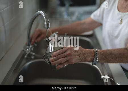 WOMAN FILLING JUG WITH TAP WATER Stock Photo - Alamy