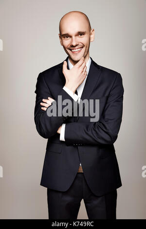 Studio shot of happy young bald muscular man smiling and thinking while ...