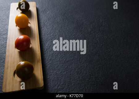 Various tomatoes arrange in wooden tray on black background Stock Photo ...