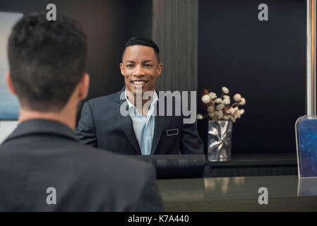 Confident hotel receptionist greeting Stock Photo - Alamy