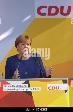 Binz, Germany. 16th Sep, 2017. German Chancellor Angela Merkel stands next to a girl and holds ...