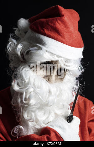 portrait of a scary looking santa claus and an elf Stock Photo - Alamy