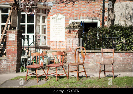 Antique shop exterior display with chairs, pile of old suitcases and ...