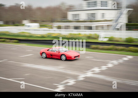 Fast red car on racetrack at Goodwood Stock Photo - Alamy