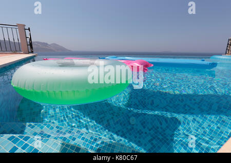 An array of lie lows and inflatable rings in a pool Stock Photo - Alamy