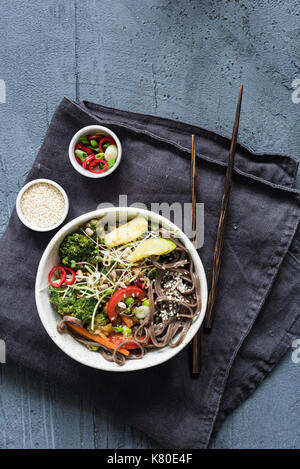 A vertical top-view of fresh Soba noodles in a white dish with black ...