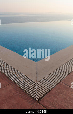 View into distance across infinity pool with lie lows and rings and sun ...