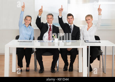 Businesspeople Team Raising Hands At Desk In Conference Stock Photo - Alamy