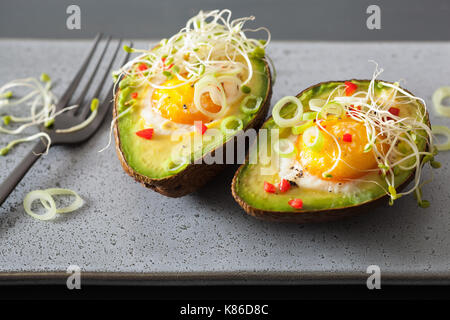 egg baked in avocado with spring onion and alfalfa sprouts Stock Photo ...