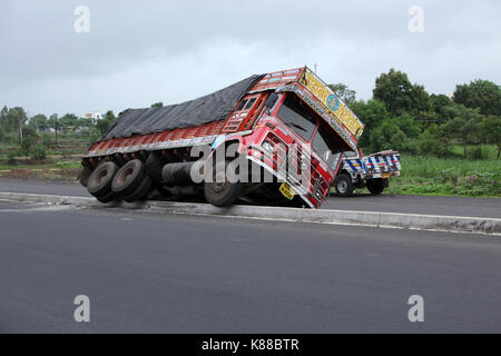 A truck toppled over on a highway in India due to speeding Stock Photo ...