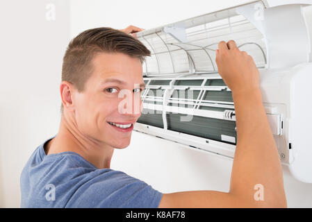 young man cleaning air conditioning system Stock Photo - Alamy
