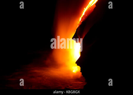 A volcanic eruption with glowing orange lava flow surrounded by a pool ...
