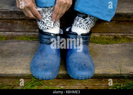 Woman sitting on steps putting on her socks and shoes Stock Photo - Alamy