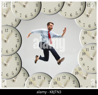 Businessman running over alarm clock Stock Photo - Alamy