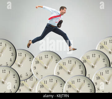 Businessman running over alarm clock Stock Photo - Alamy