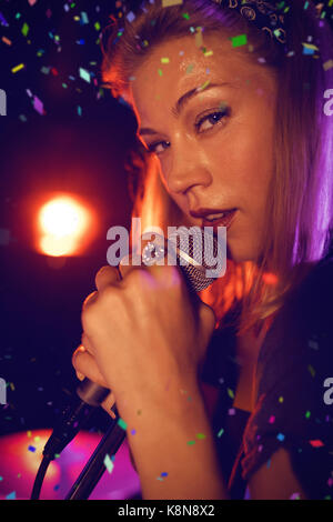 Flying colours against female singer performing at music concert Stock ...