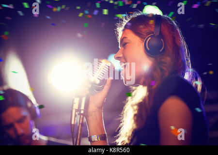 Flying colours against female singer performing at music concert Stock ...