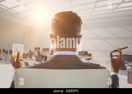 Rear view of businessman holding whisky glass and cigar against ...