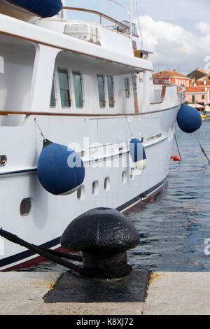 A short, thick post on the deck of a ship or on a wharf, to which a ...