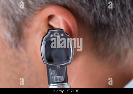 Doctor Looking At Patient's Ear Through Otoscope Stock Photo - Alamy
