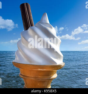 Ninety Nine ice cream cone with raspberry against blues sky and sea. UK ...