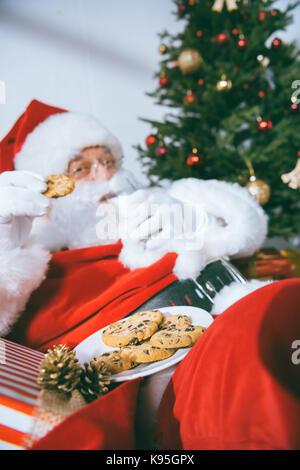 Santa eating cookies Stock Photo - Alamy